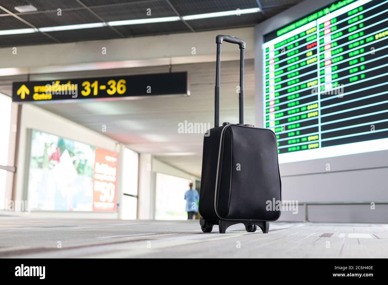 Passenger luggage wait and look at terminal gate information board ...