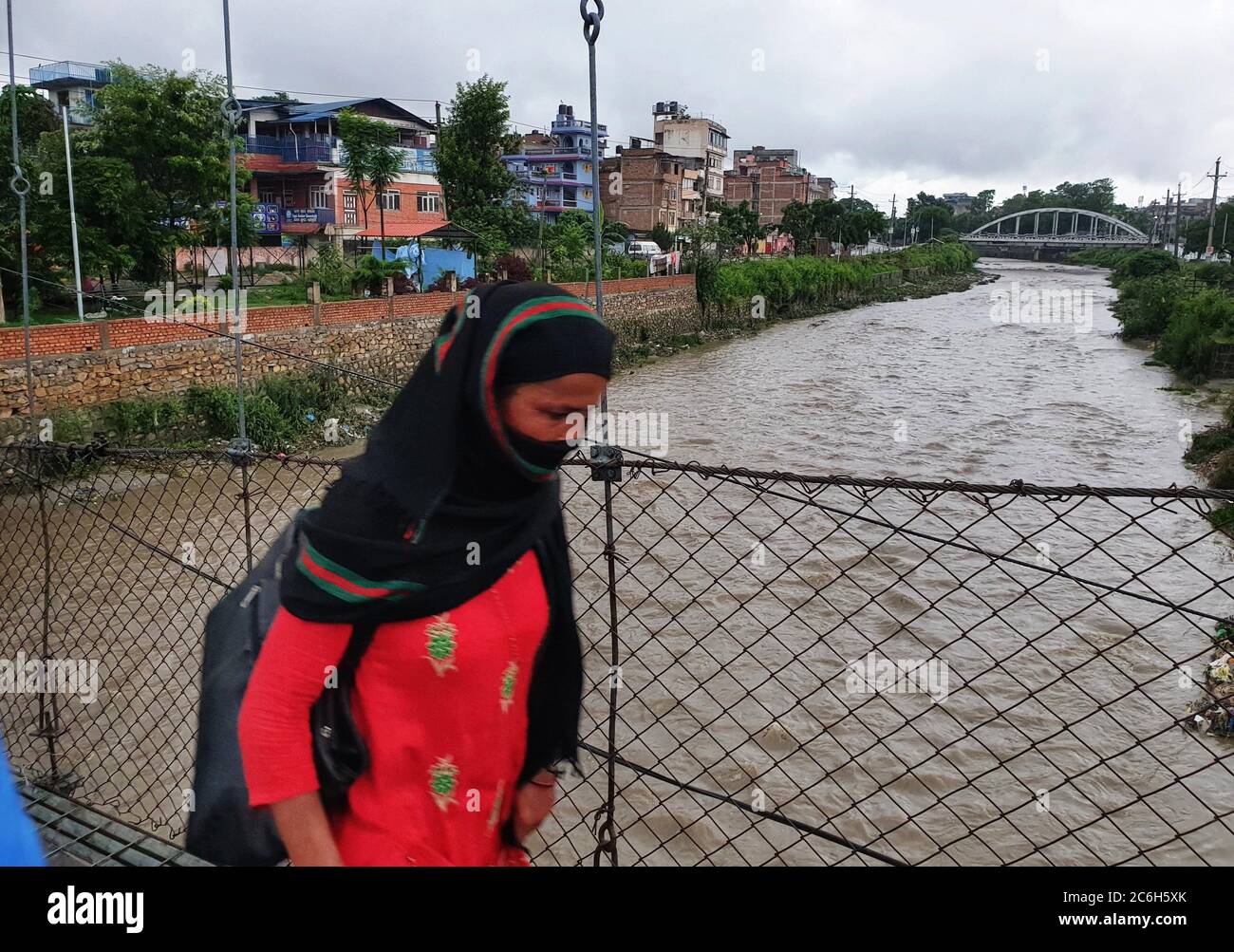 Kathmandu, Nepal. 10th July, 2020. A Nepali woman walks on the bridge ...
