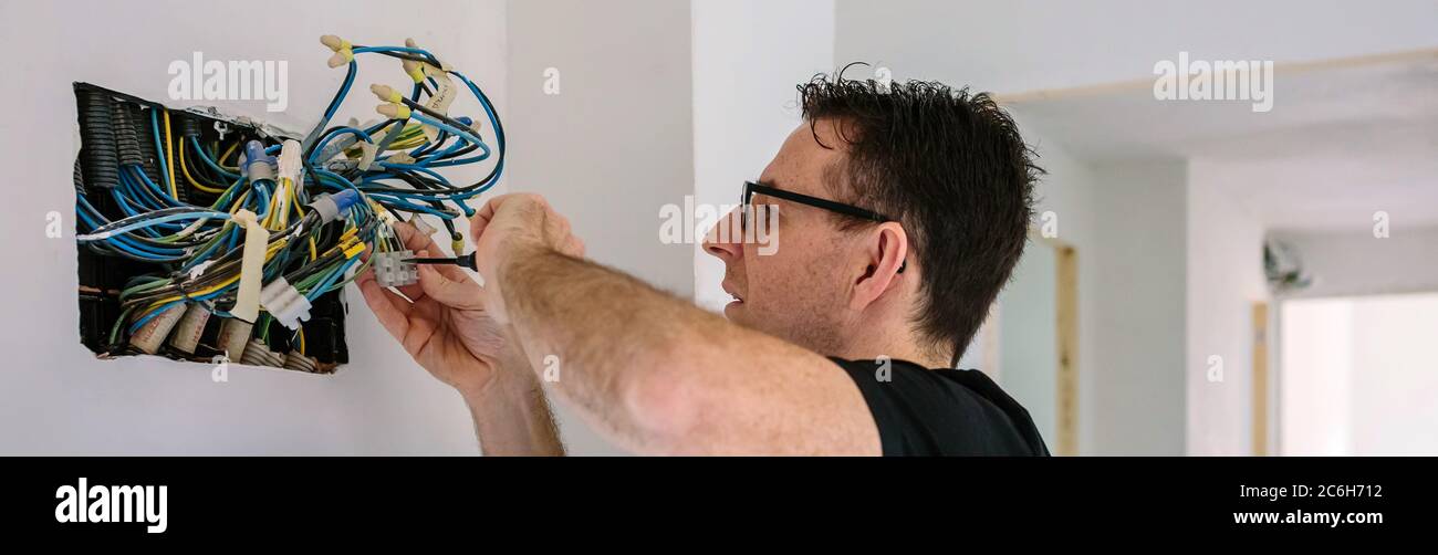 Electrician working on the electrical installation of a house Stock ...