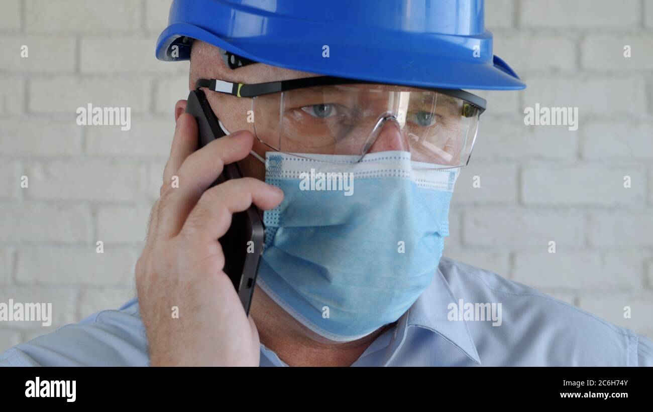 Engineer with Safety Helmet and a Protection Mask on His Face Talking ...
