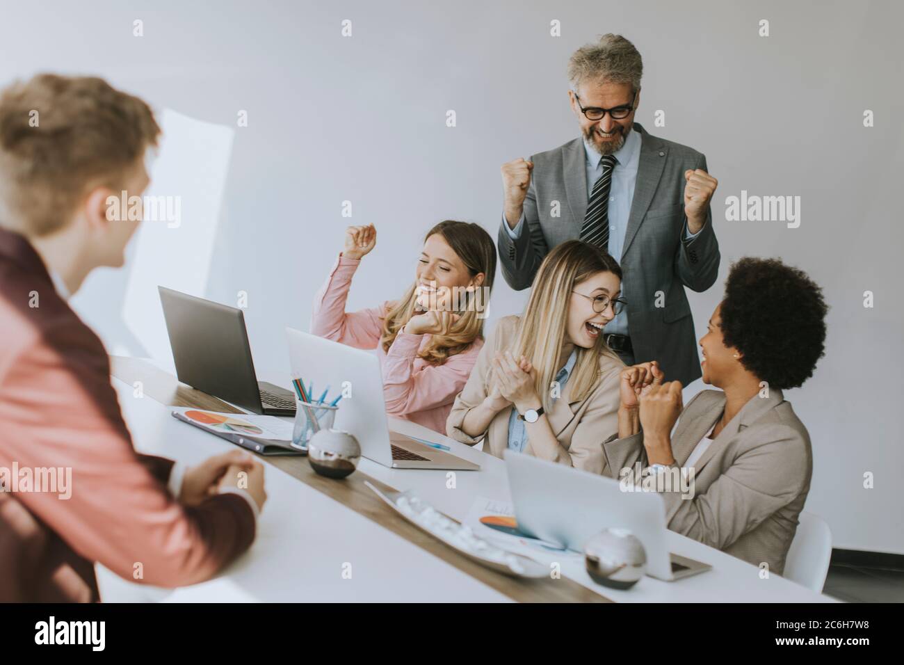 Group of multiethnic business people hear great news while working on ...