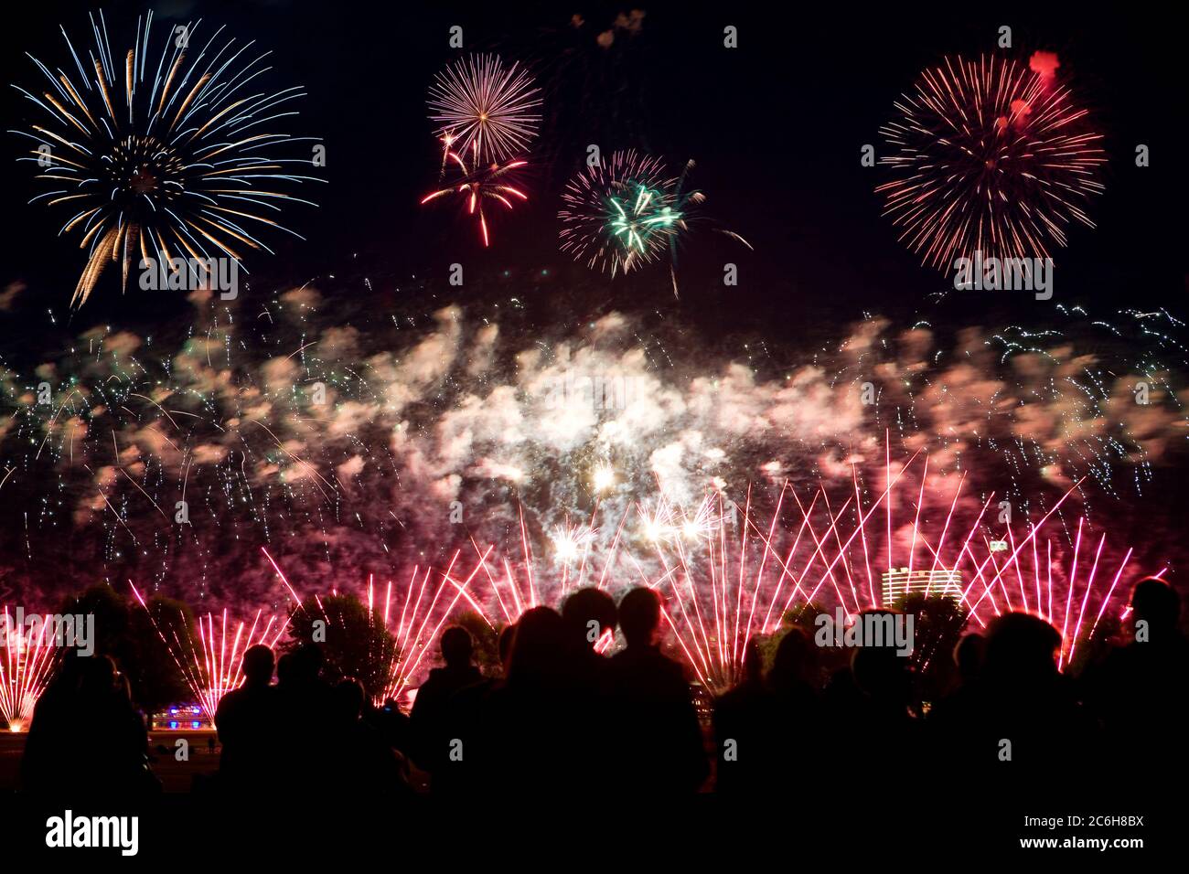 multiple fireworks against a black sky, crowd in the foreground Stock ...