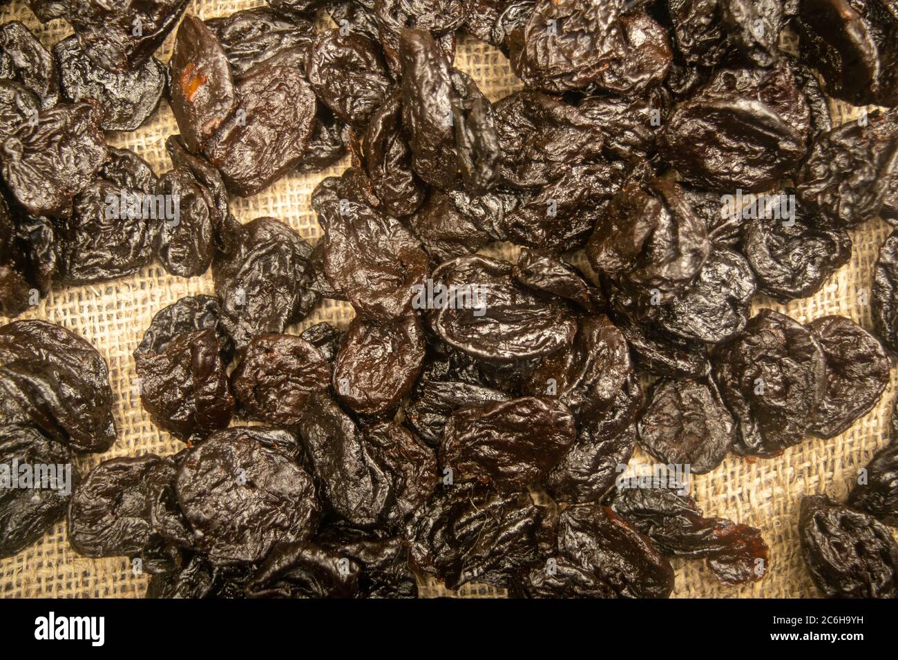Dried prunes in bulk on burlap with a rough texture. Close up Stock ...