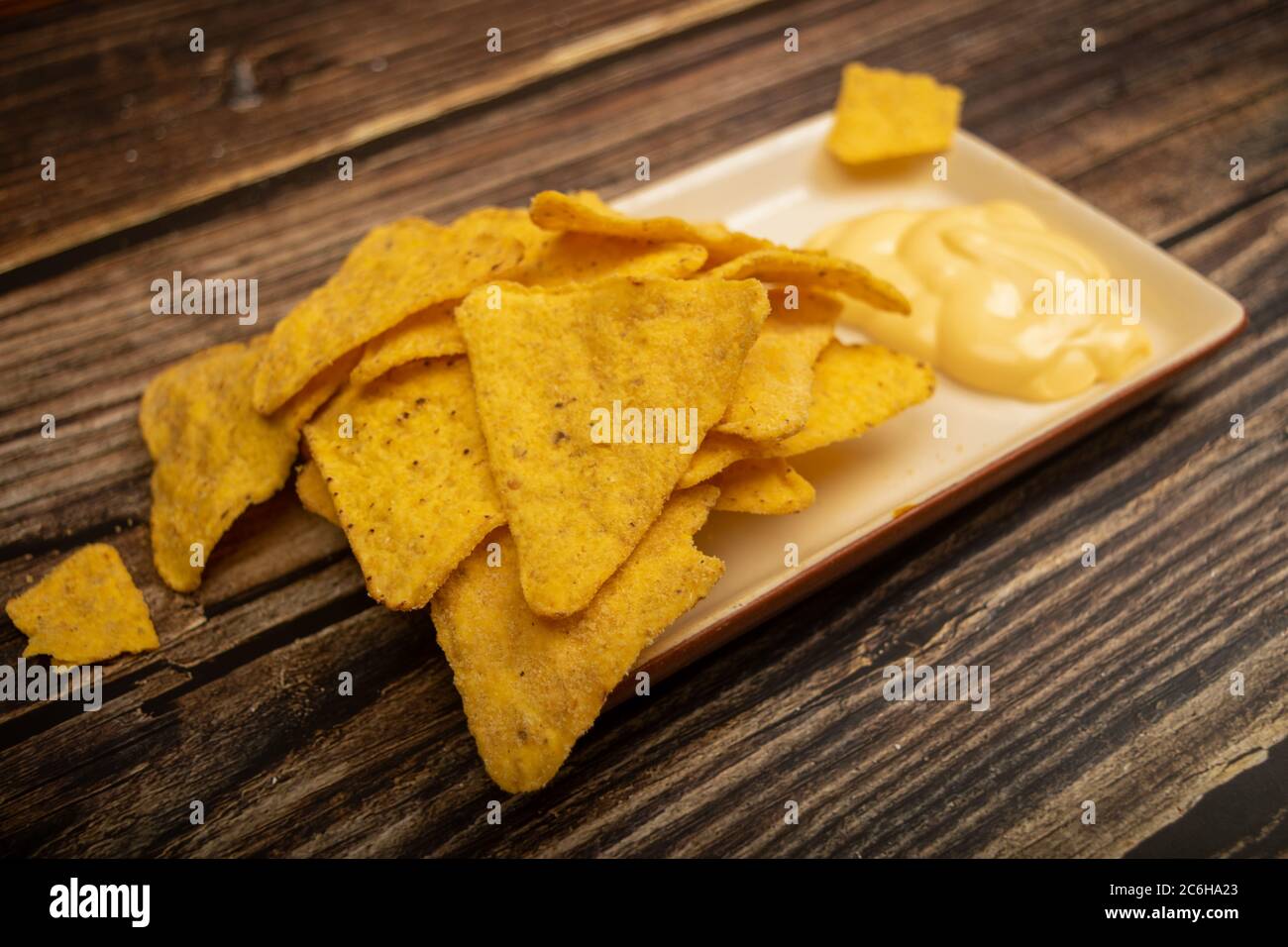 Corn chips with cheese sauce on a wooden background. Close up Stock ...