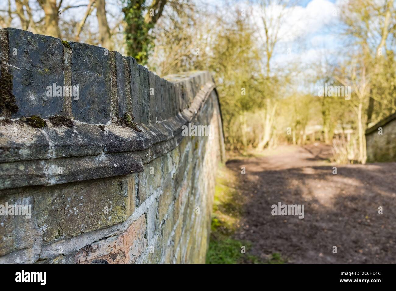 Close-up image of an old and weathered brick built foot bridge crossing ...
