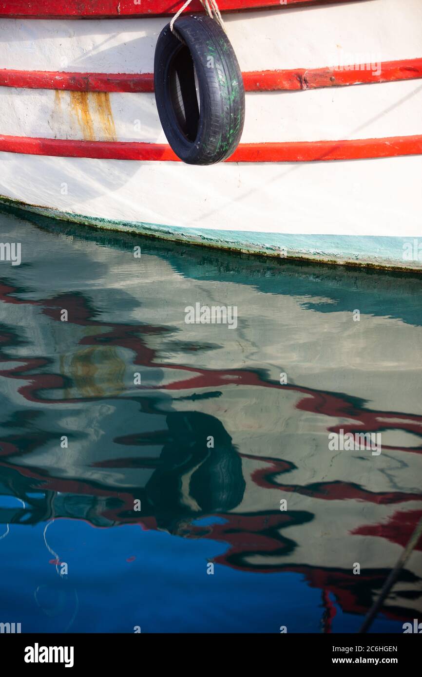 Artistic reflection of a wooden fishing boat with tyre in water Stock ...