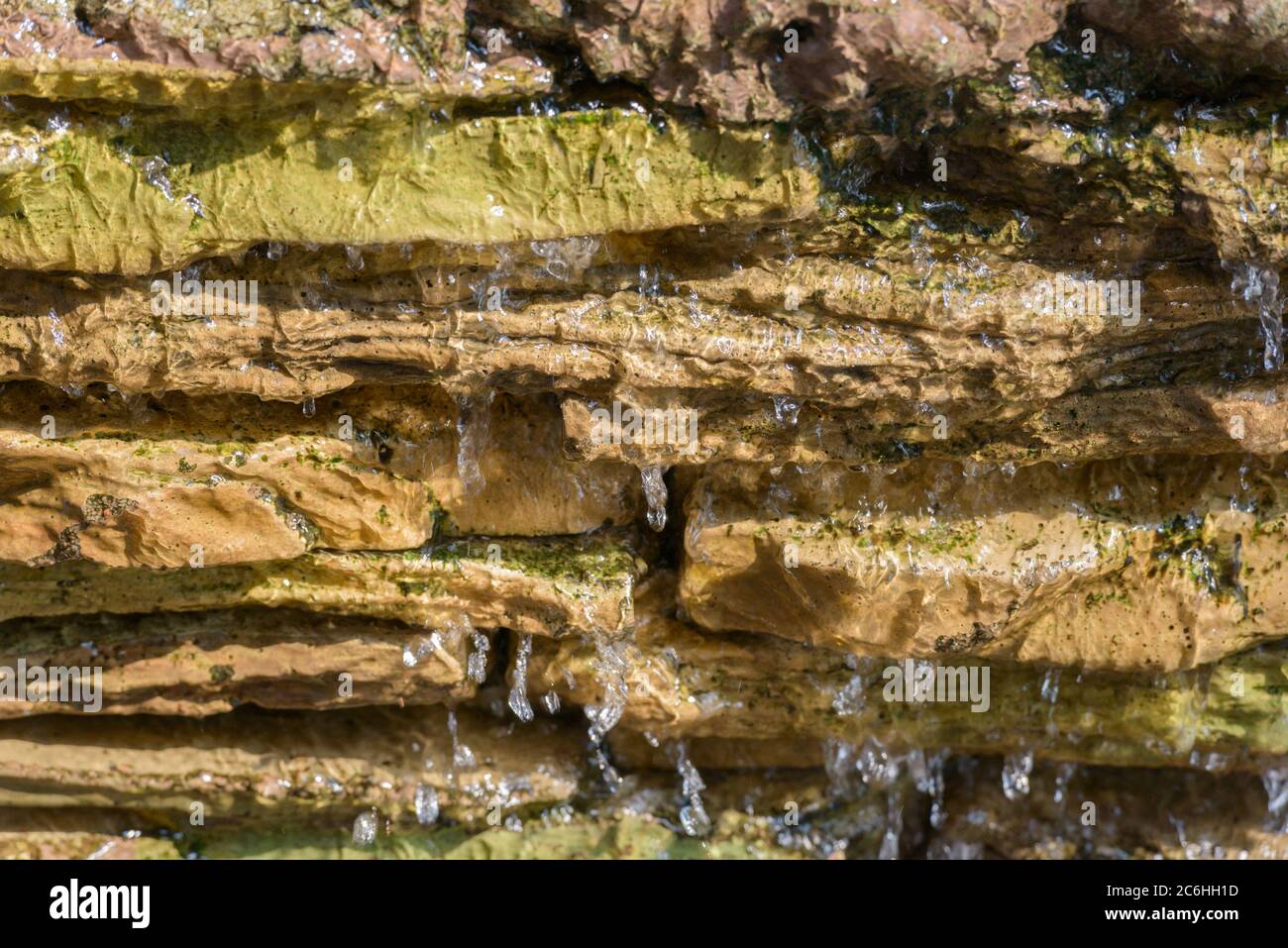 Stone wall water dripping down as miniature waterfall Stock Photo - Alamy