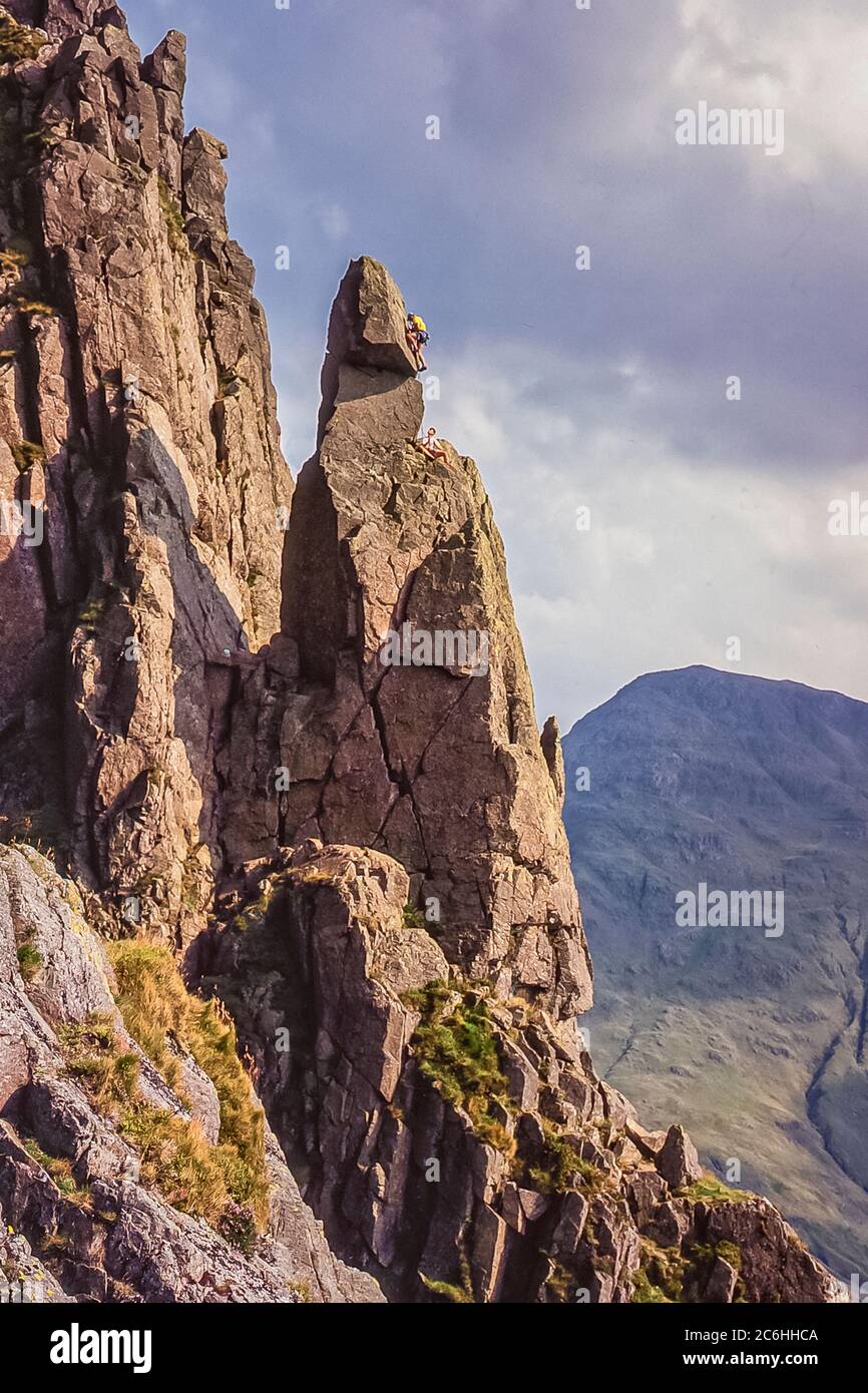 The image shows rock climbers in action scaling the Napes Needle rock ...