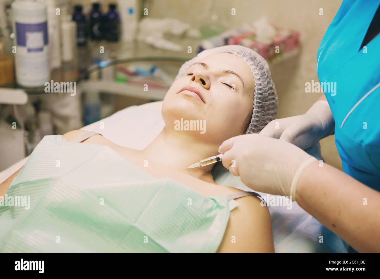 Beautician performs a needle mesotherapy treatment on a woman's face ...