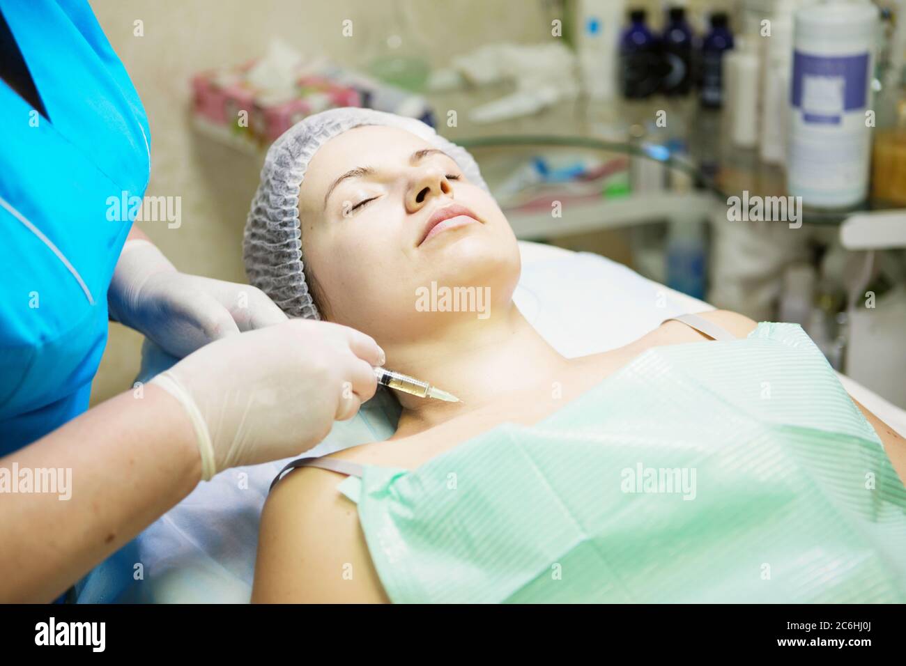 Beautician performs a needle mesotherapy treatment on a woman's face ...