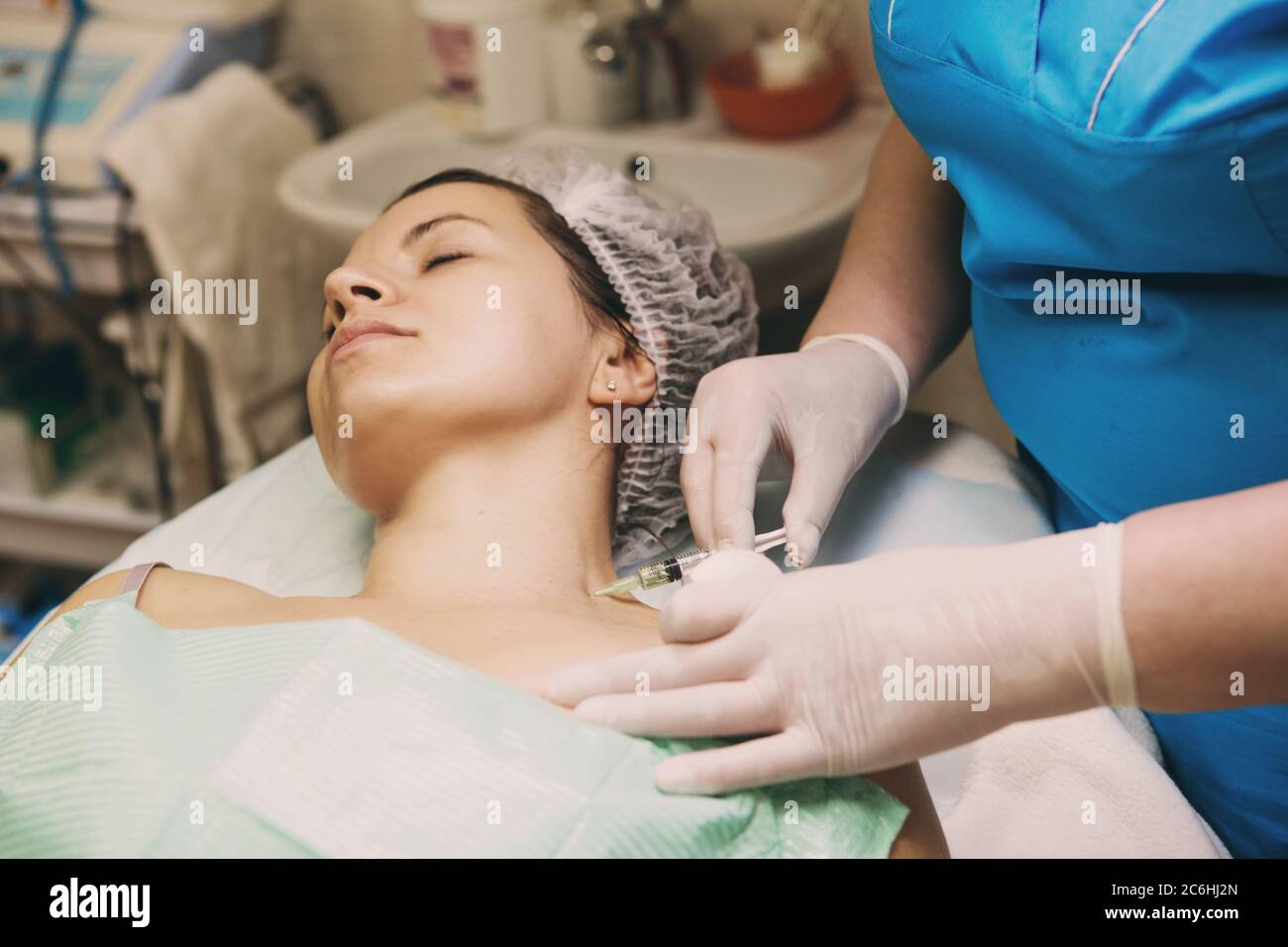 Beautician performs a needle mesotherapy treatment on a woman's face ...