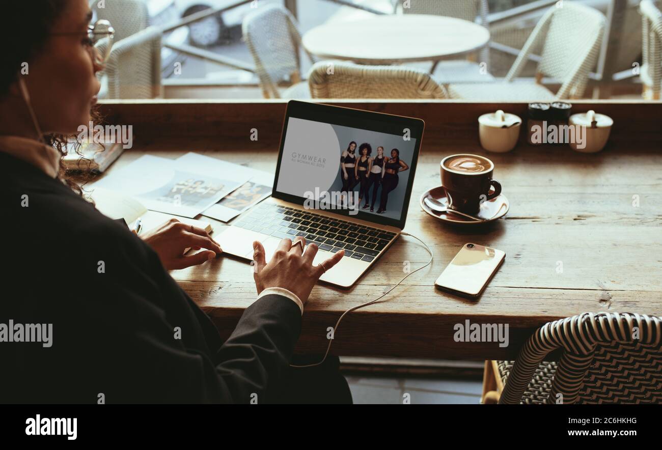 Businesswoman working on her laptop at a cafe. Woman sitting at a ...