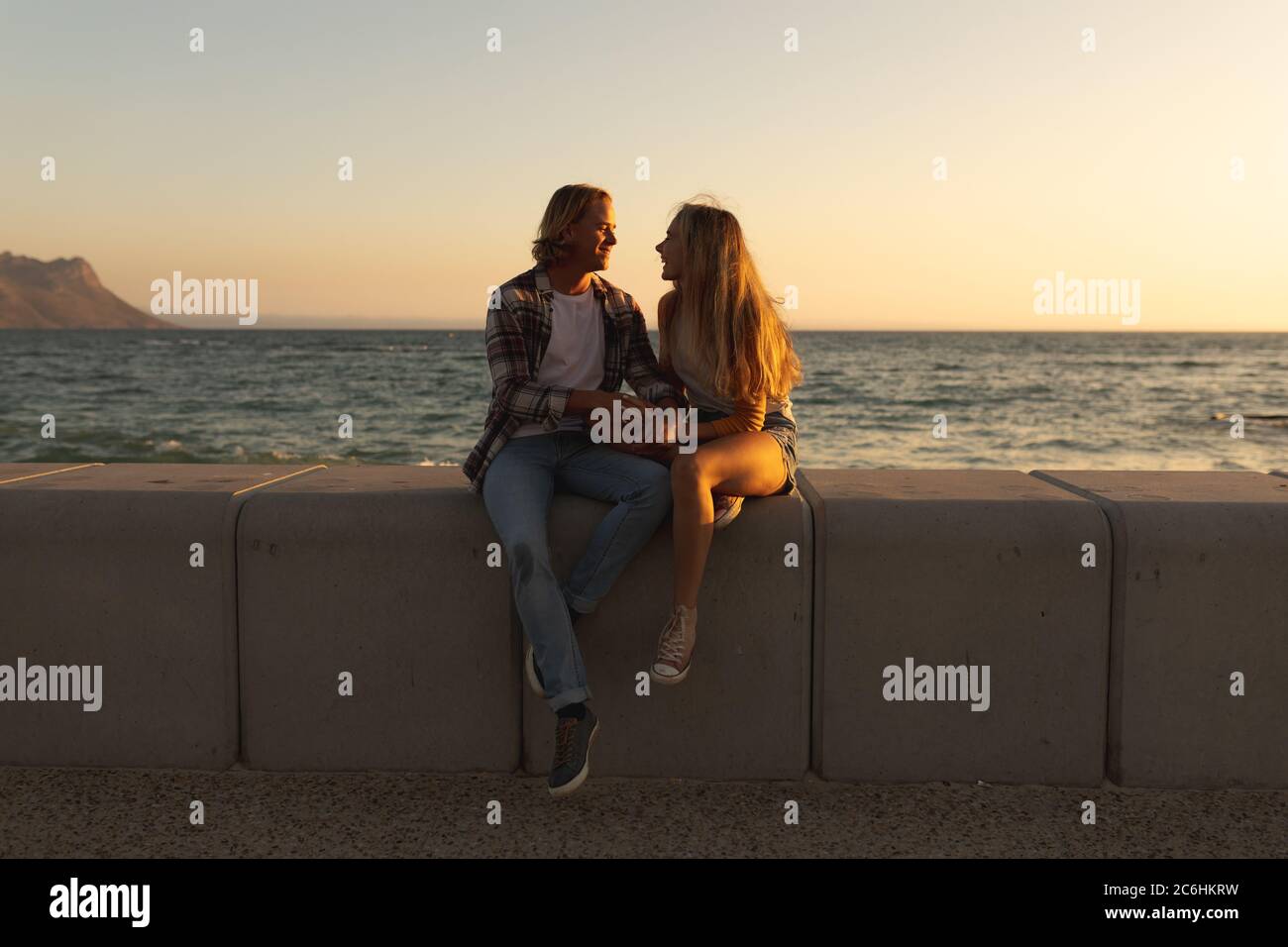 Caucasian couple enjoying their time on a promenade during a sunset ...