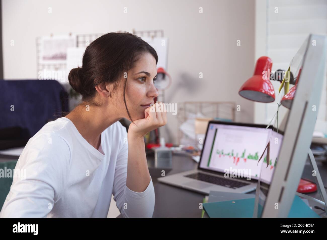 Woman using computer while sitting on her desk Stock Photo - Alamy
