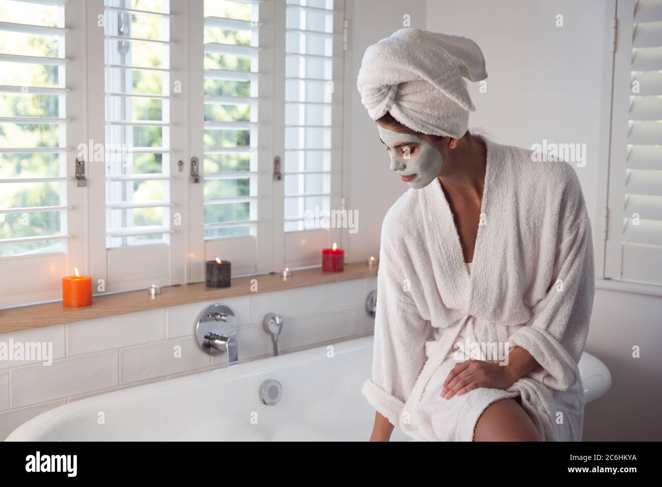 Woman in facial mask sitting on a bathtub in bathroom Stock Photo - Alamy