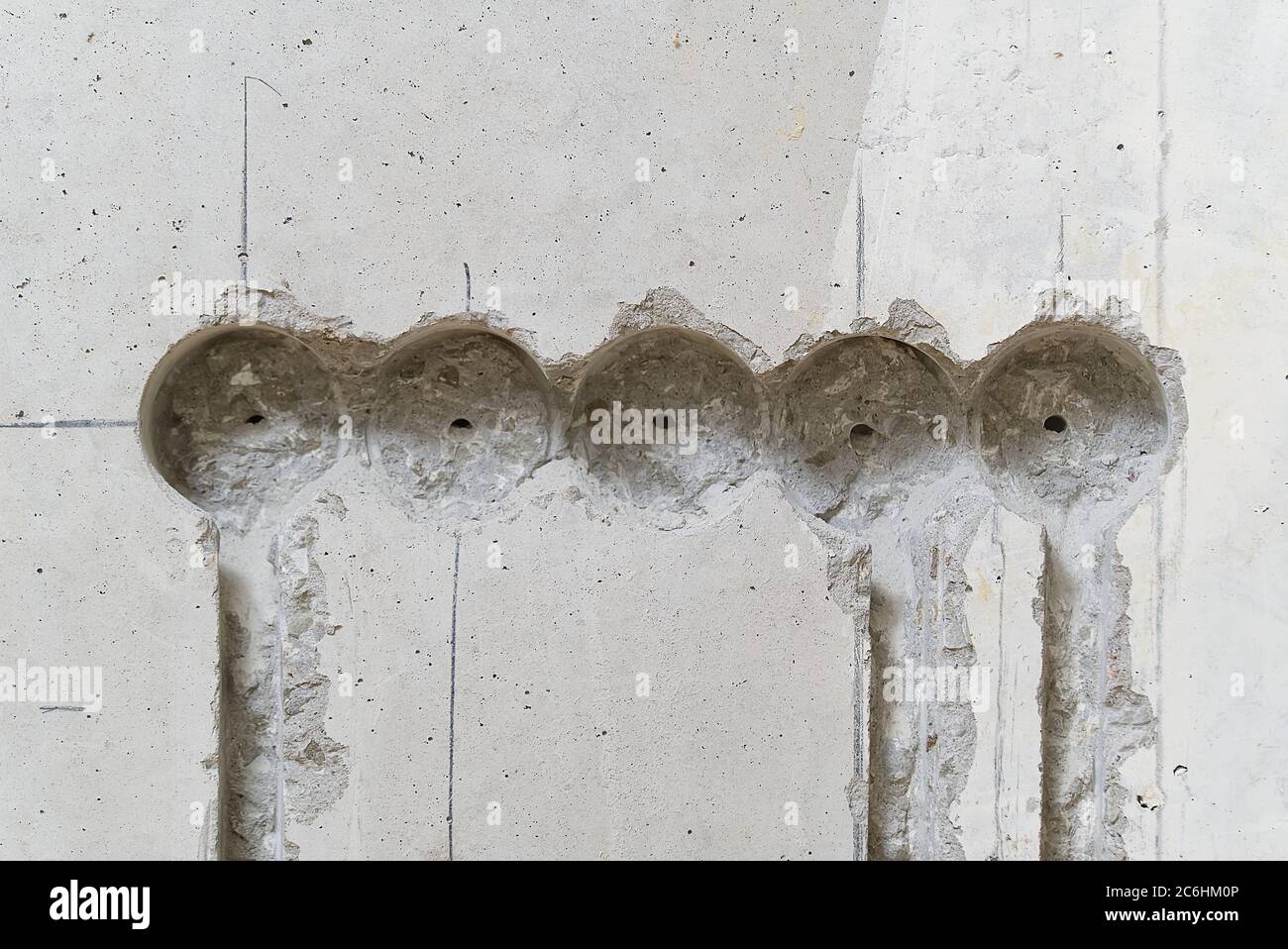 Holes in a concrete wall for installing plastic boxes under sockets ...
