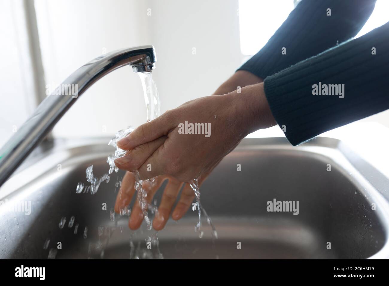 Mid section of woman washing her hands in the sink Stock Photo - Alamy