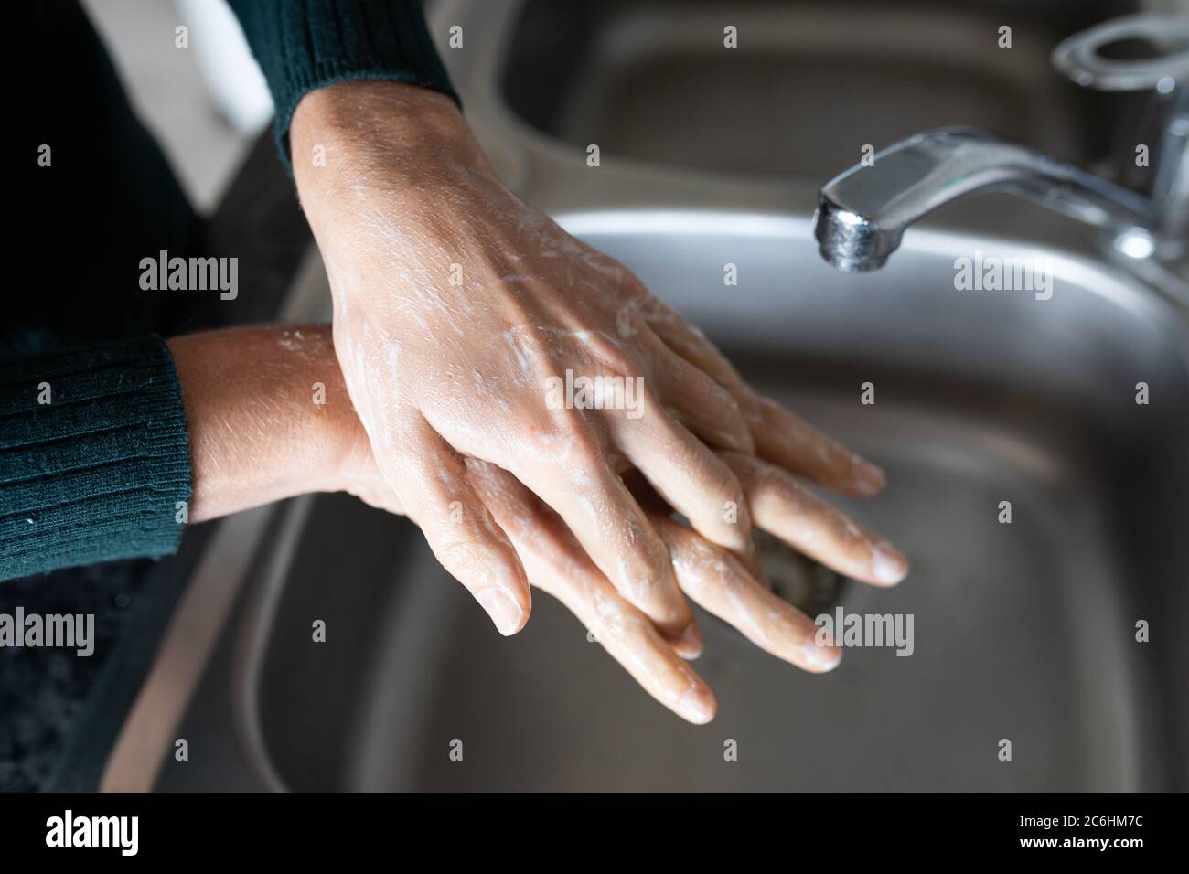 Mid section of woman washing her hands in the sink Stock Photo - Alamy