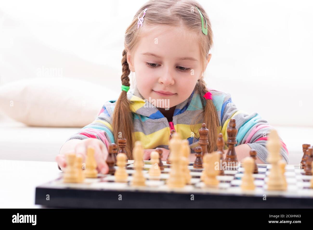 Cute little girl playing chess at home Stock Photo - Alamy