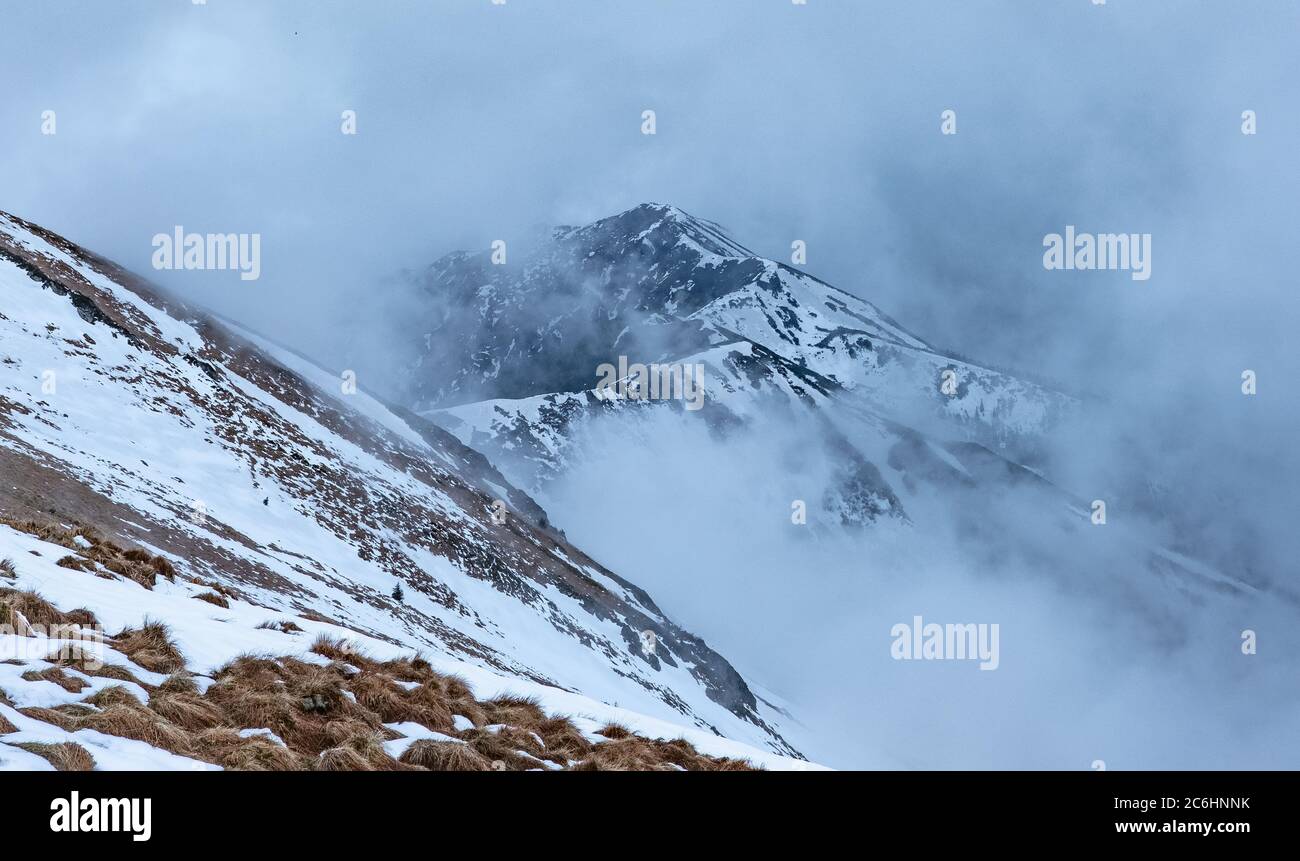 Thick fog on the snowy rock mountain pass Stock Photo - Alamy