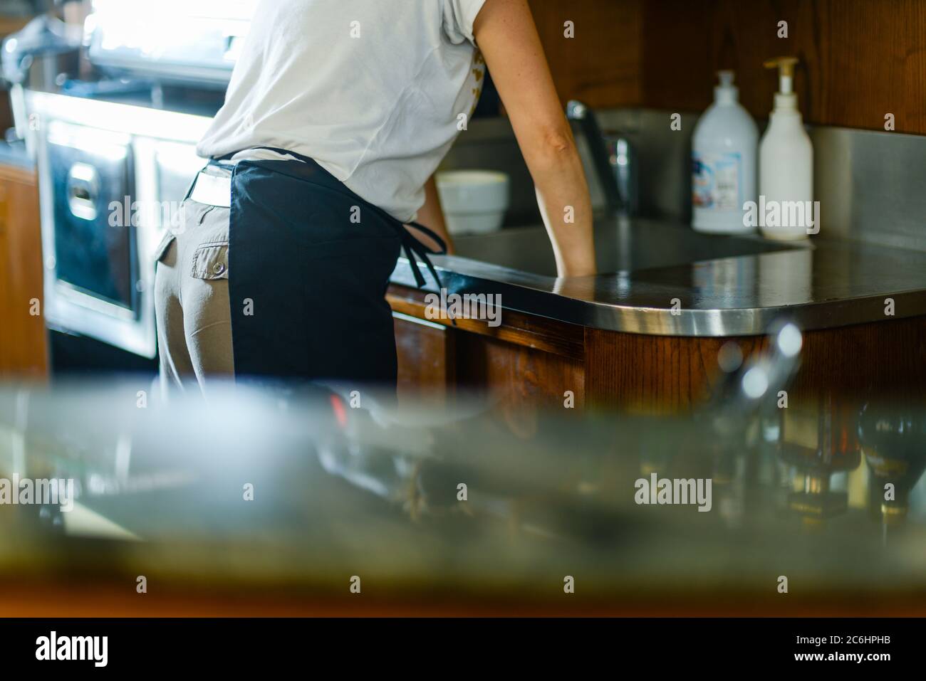 Bartender washing dishes and cups in a small bar Stock Photo - Alamy
