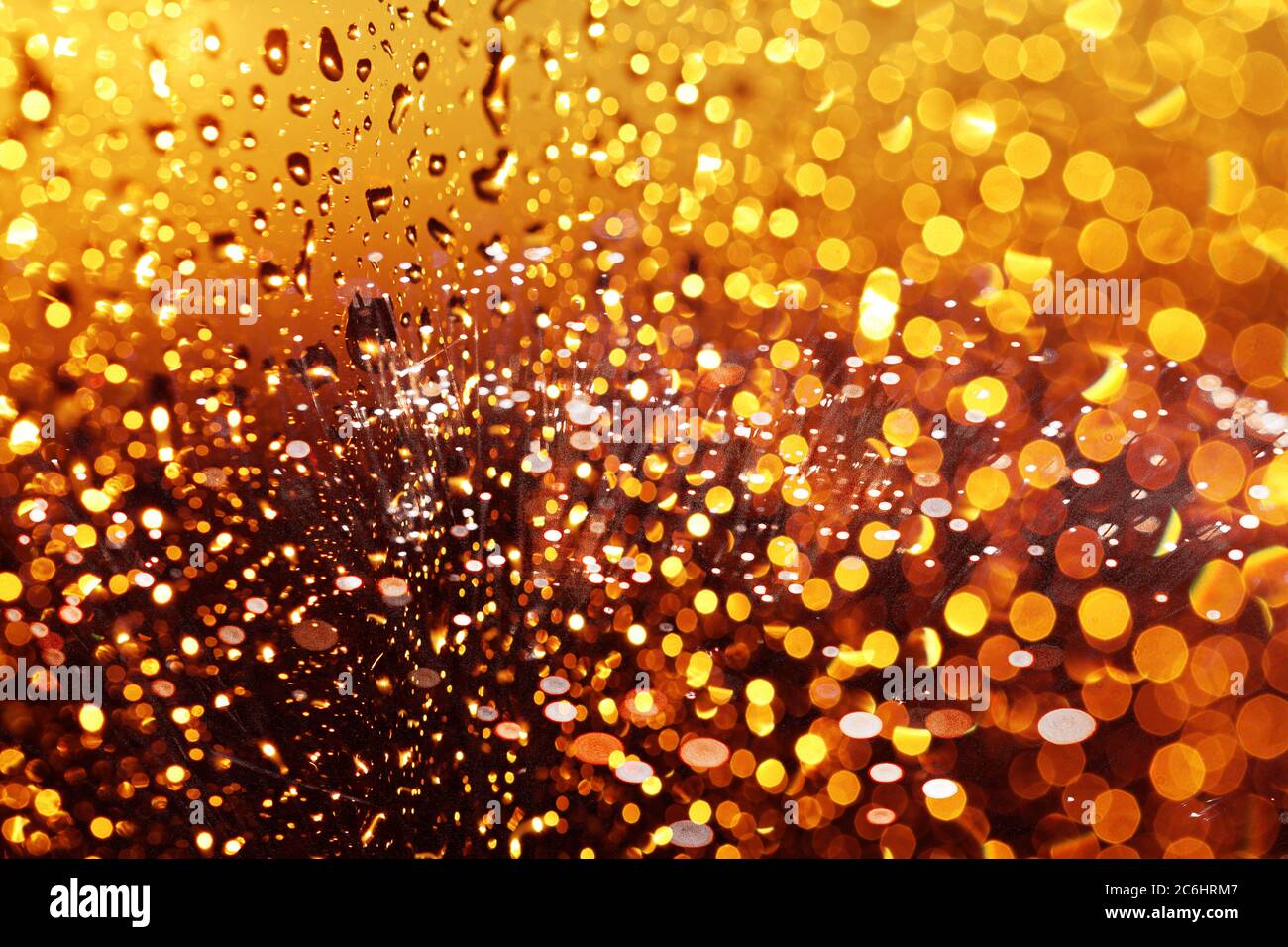 Rainy water drop through a window. glowing golden particles Stock Photo ...