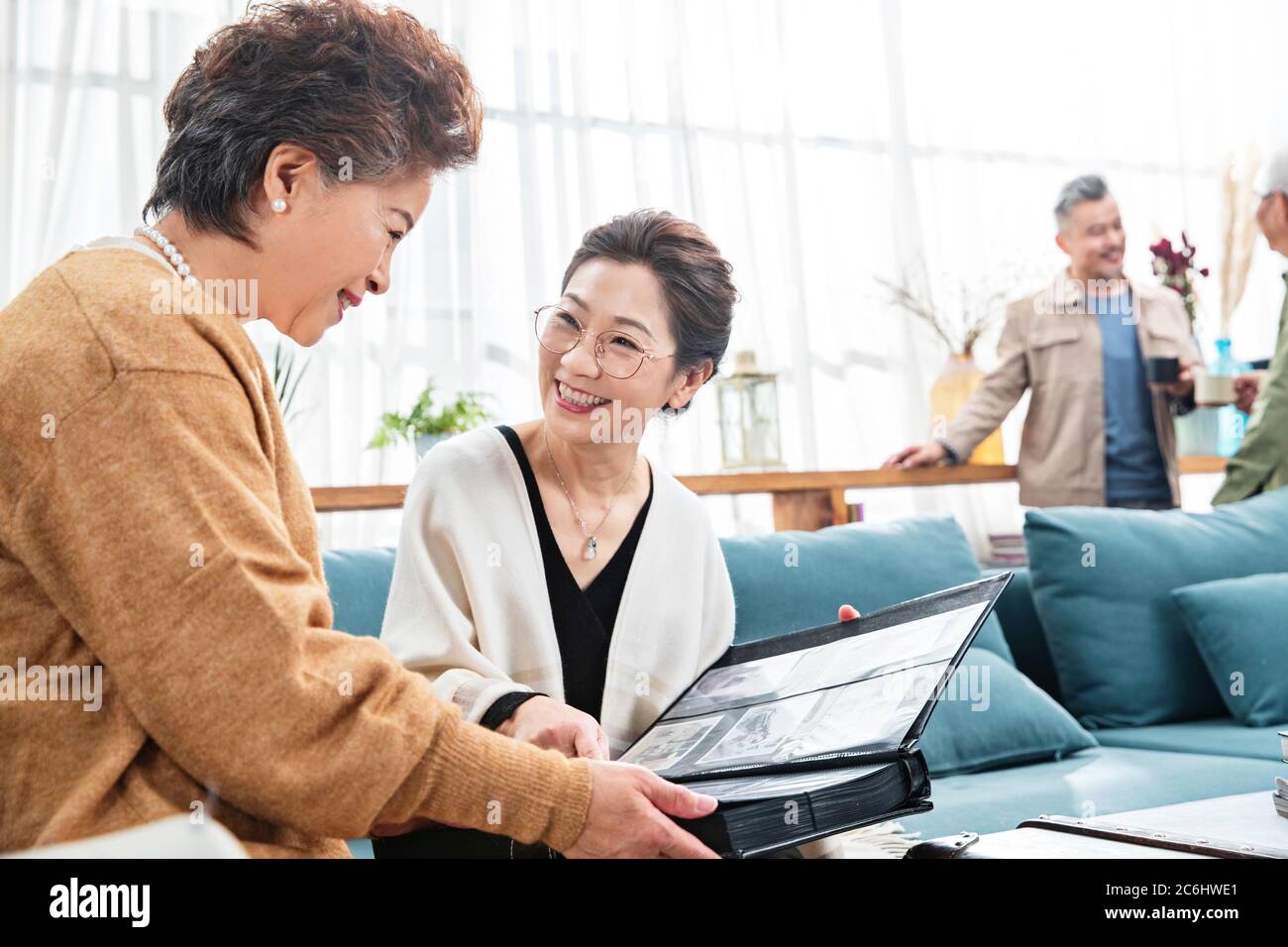 Middle-aged and old friends to see photo album photos Stock Photo - Alamy