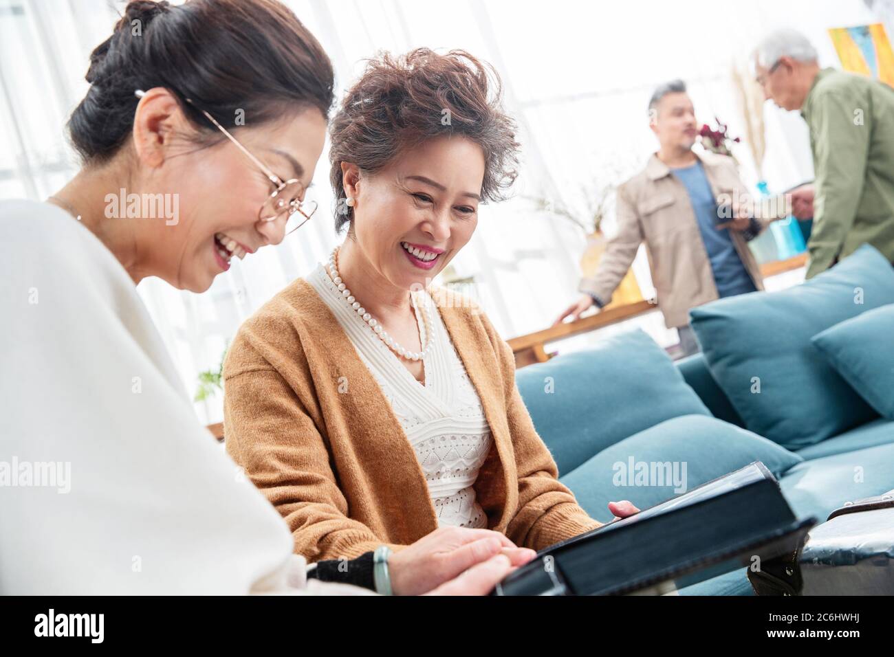 Happy middle-aged and old friends to see photo album Stock Photo - Alamy