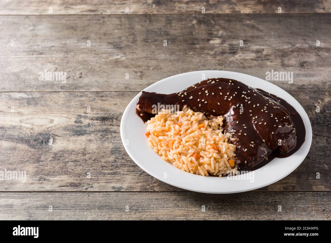 Traditional mole Poblano with rice in plate on wooden table.Copy space ...