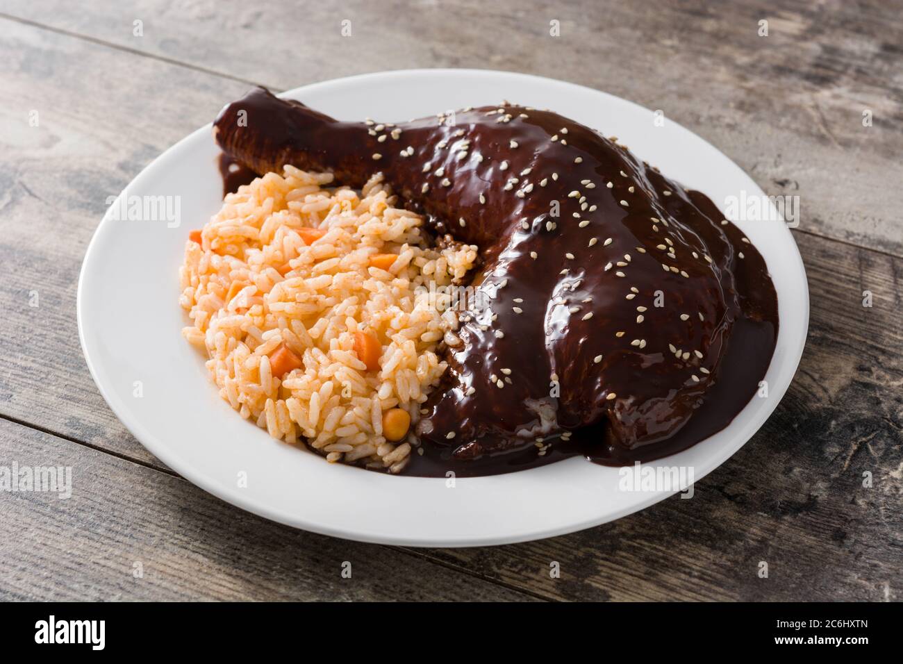 Traditional mole Poblano with rice in plate on wooden table Stock Photo ...