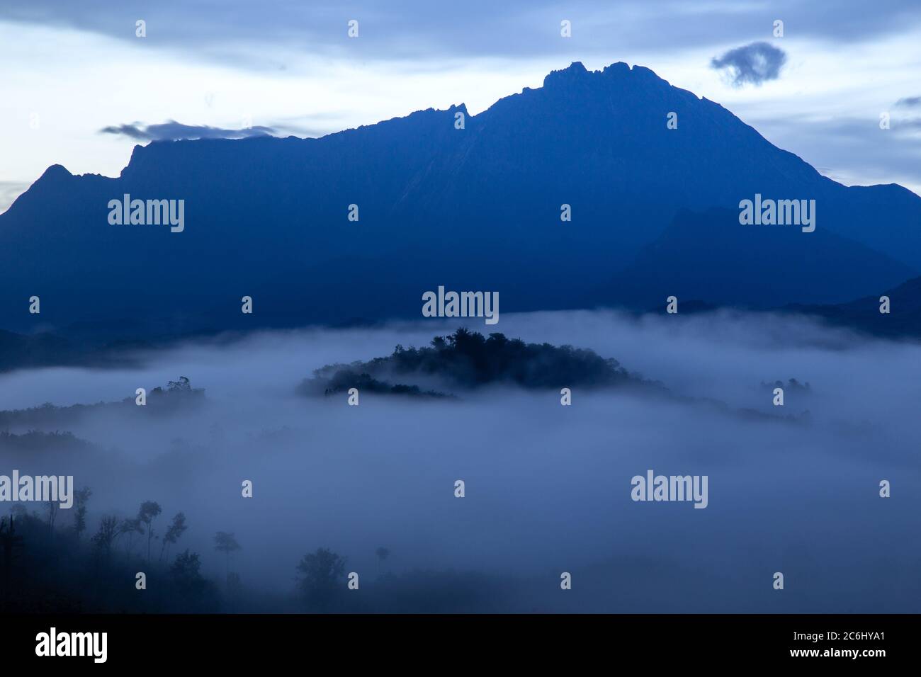 Beautiful landscape scenery with sunlight and fog and Mount Kinabalu as ...