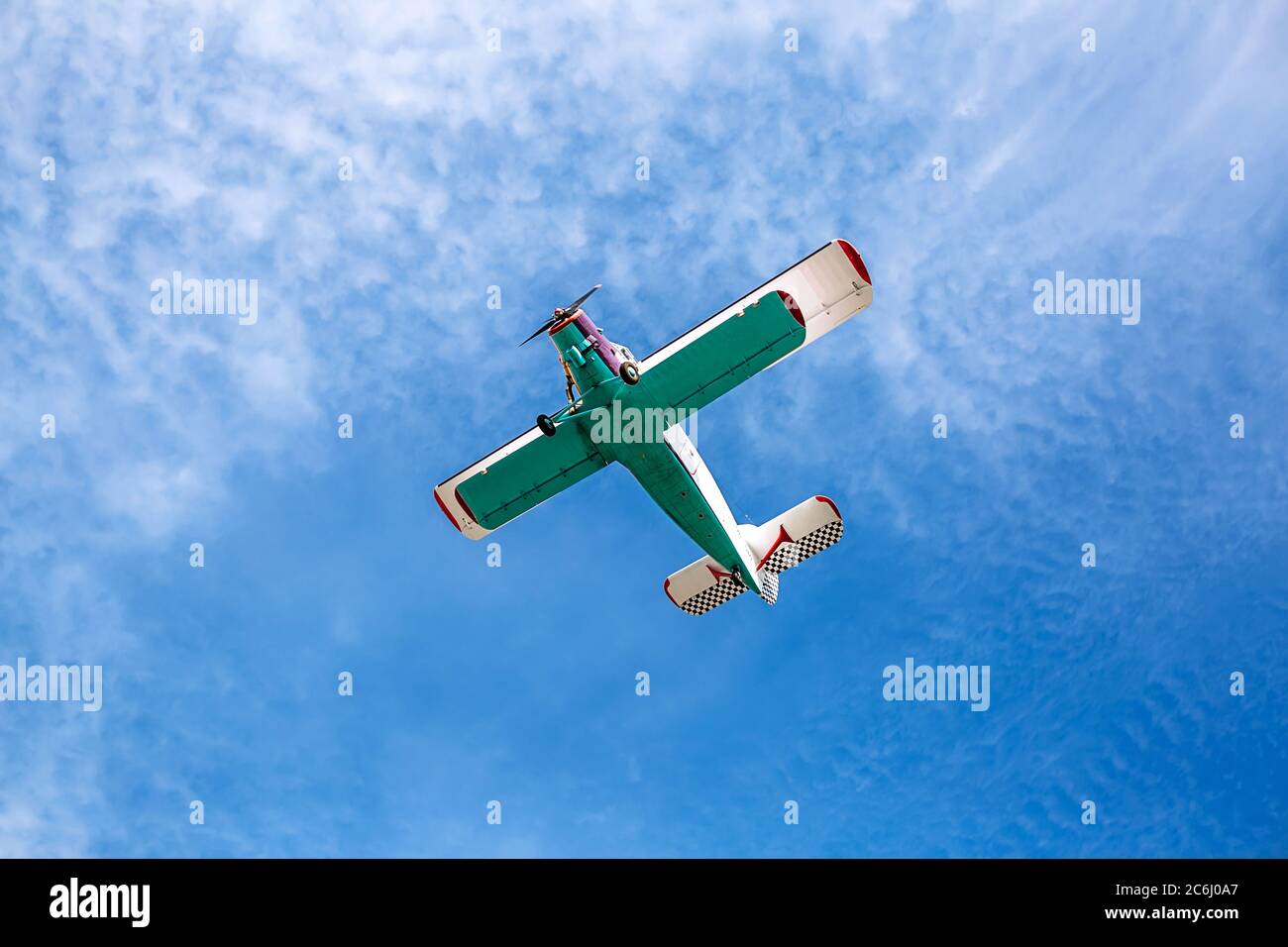 Small single engine four wings vintage airplane in a deep blue cloudy ...