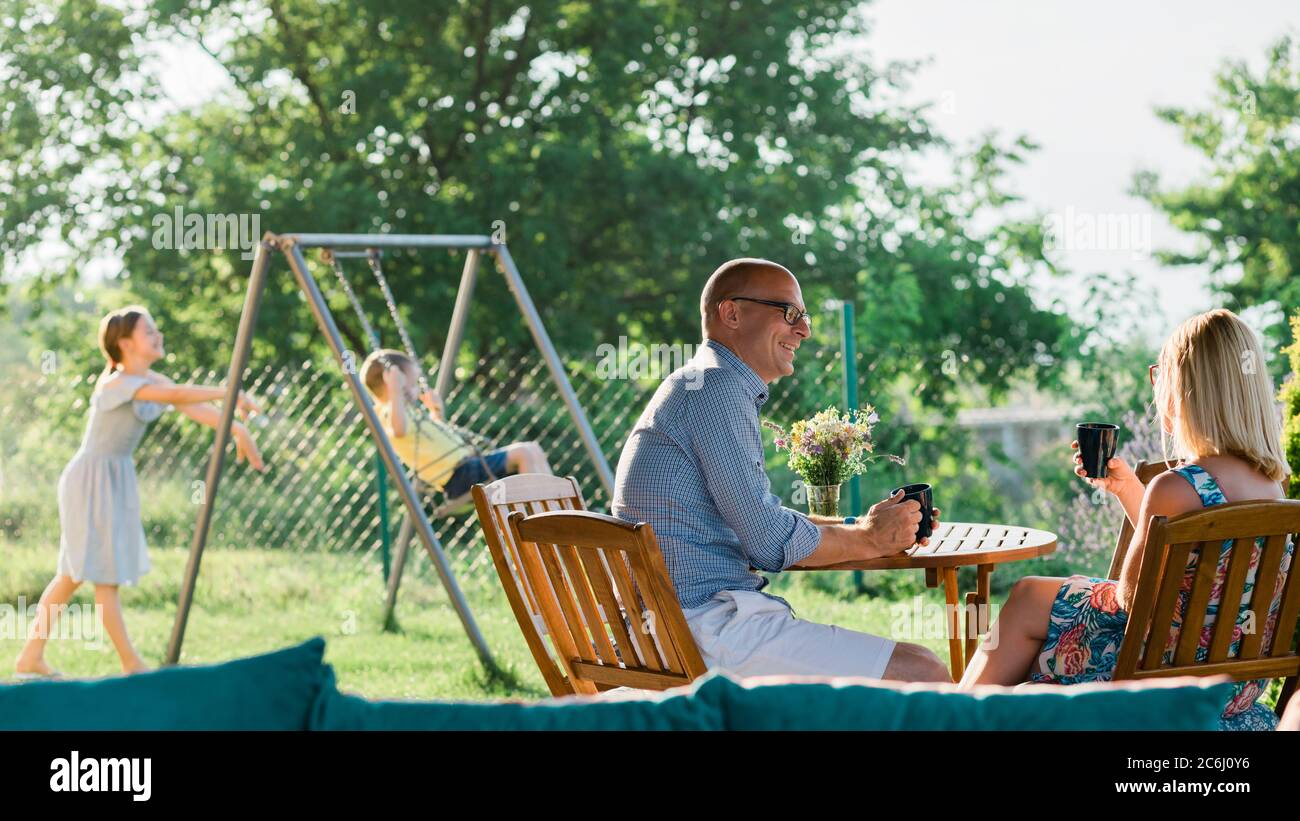 Young family enjoying a day in the backyard Stock Photo - Alamy