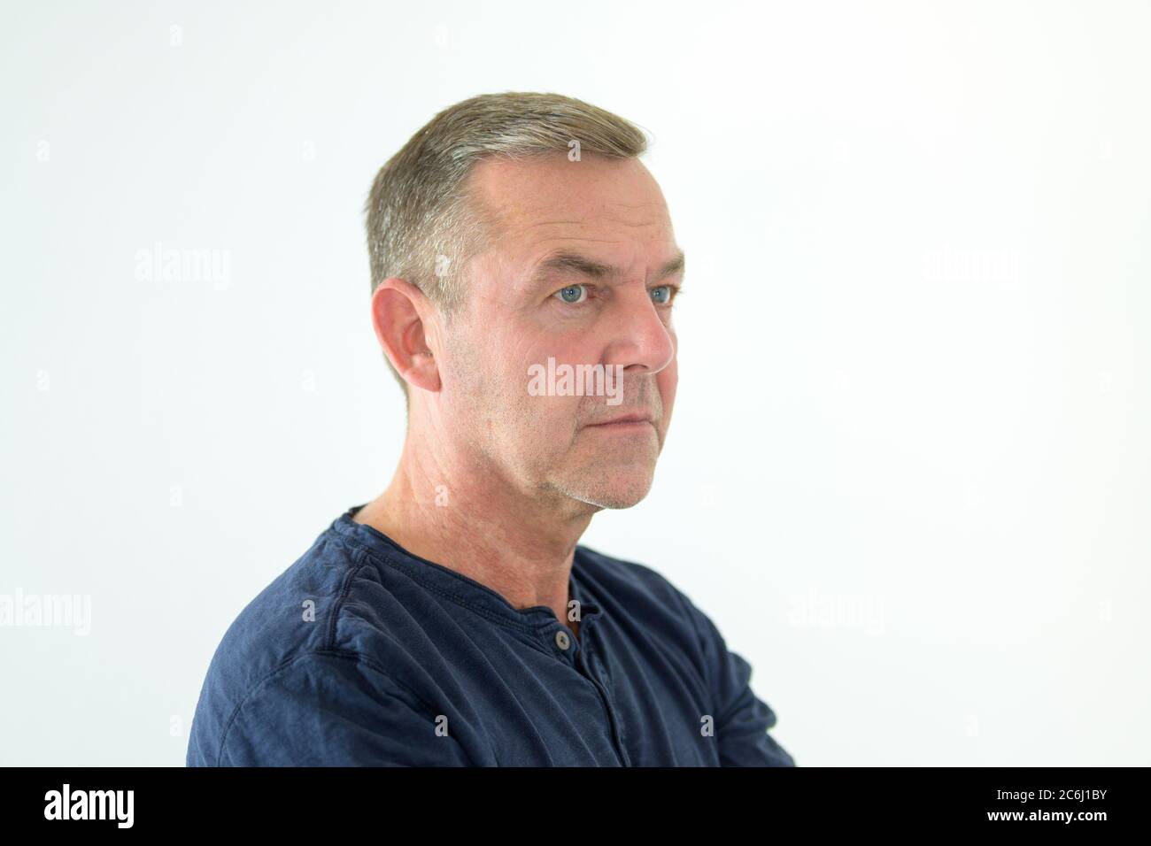 Three-quarter pose of a serious thoughtful middle-aged man looking ...