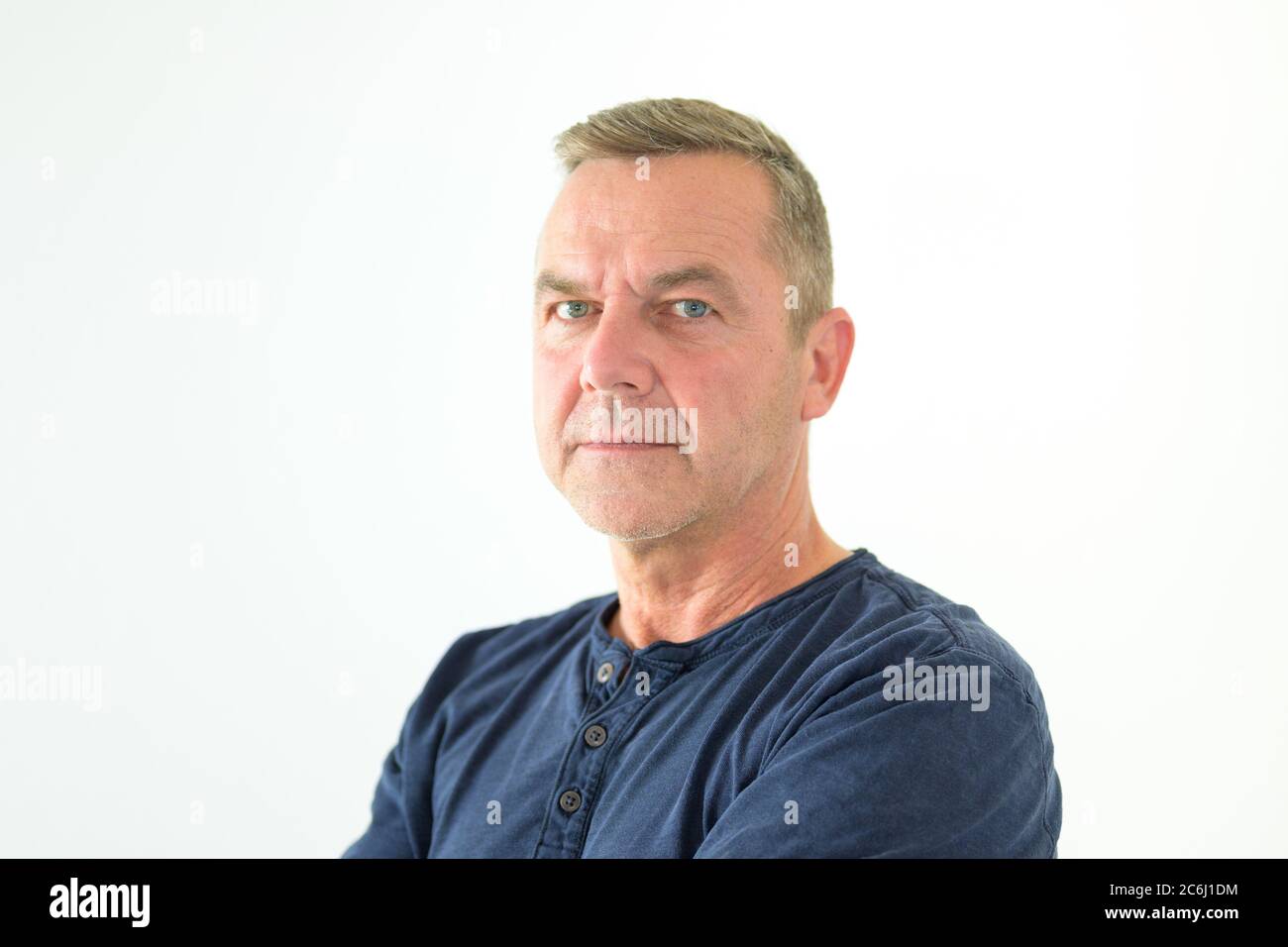 Thoughtful man glancing sideways at the camera with a serious ...