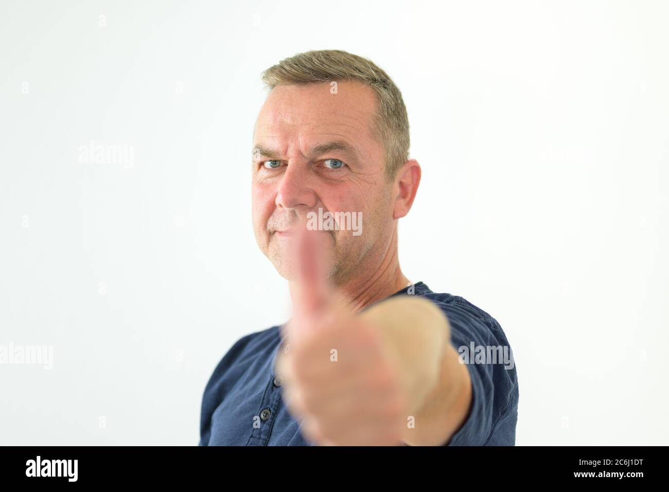 Determined man giving a thumbs up gesture of positivity and approval ...