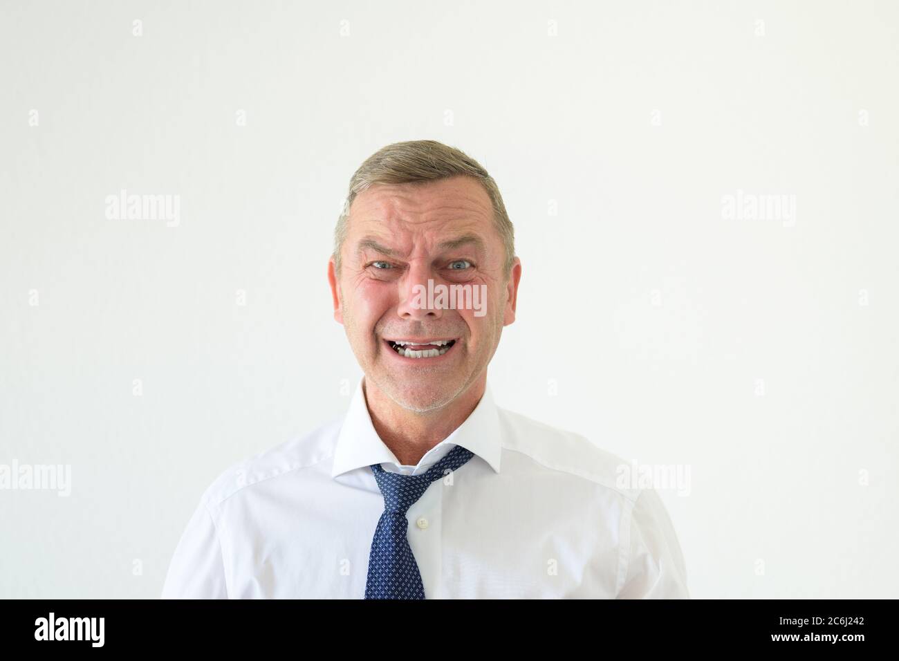 Agonised middle-aged man looking at the camera in anguish in a head and ...