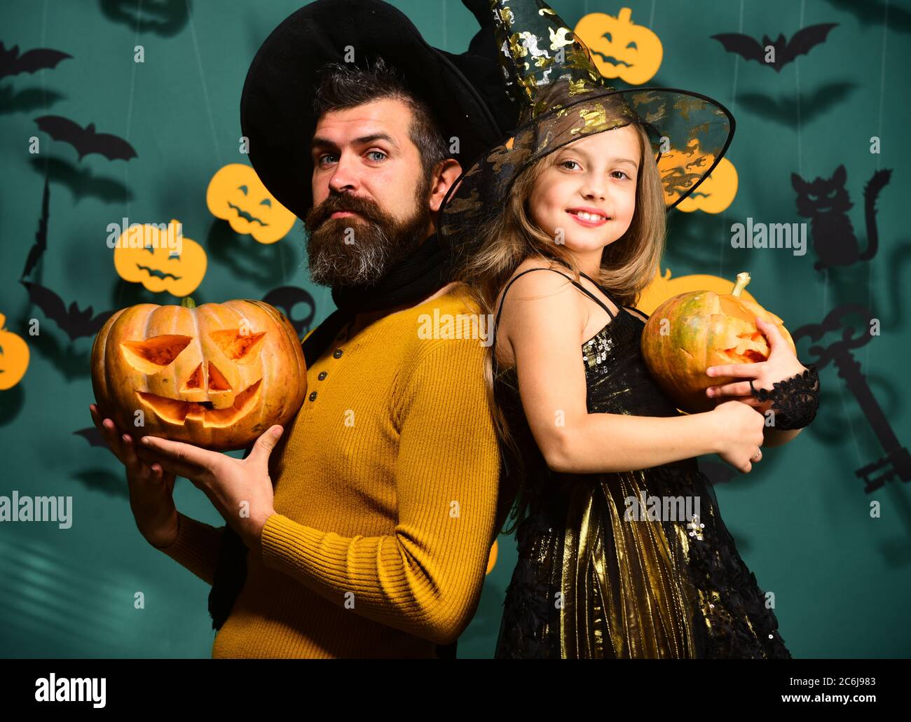 Halloween party and festival concept. Wizard and little witch in black ...