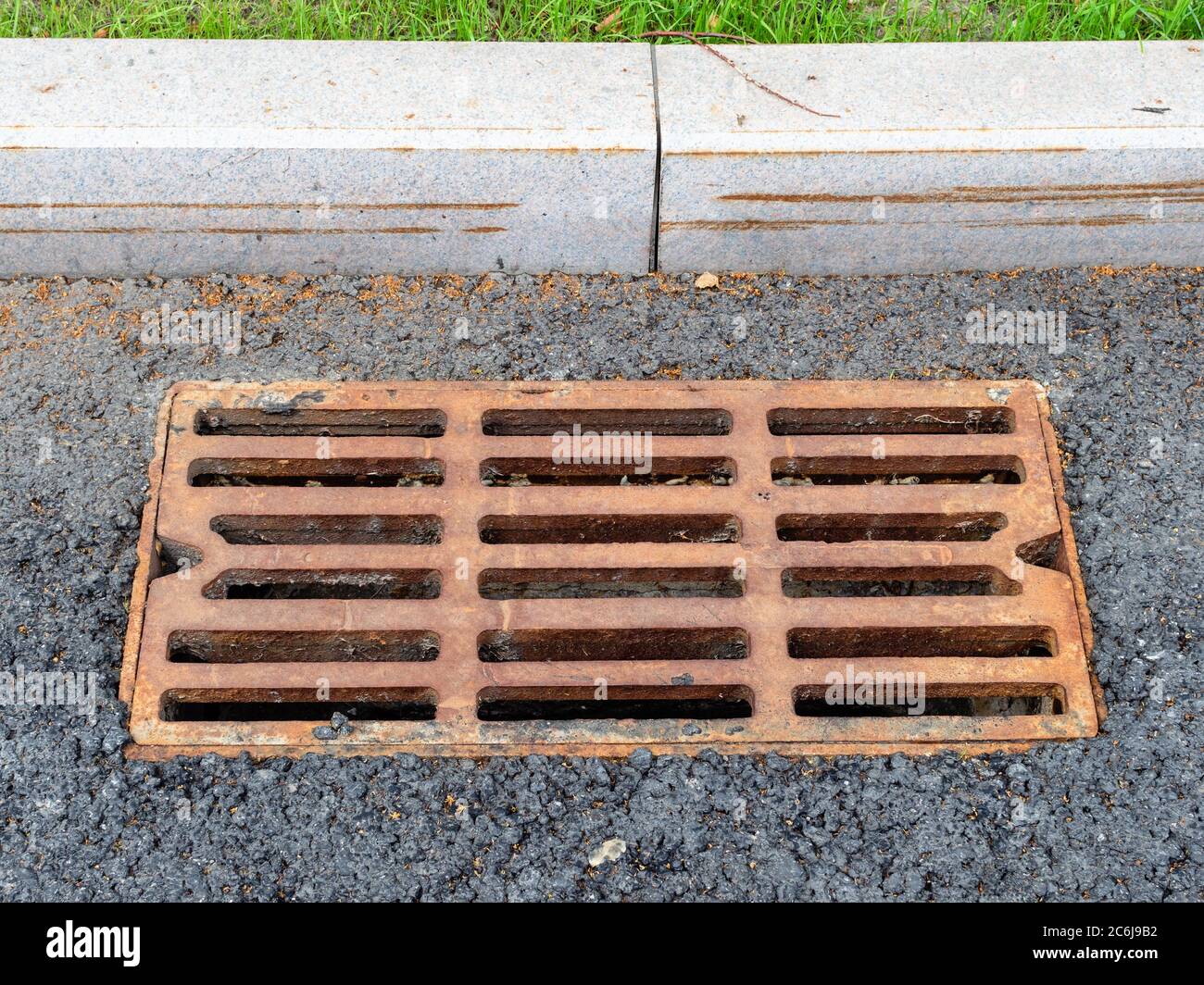 rusty grate of drain system on new city asphalt road Stock Photo - Alamy