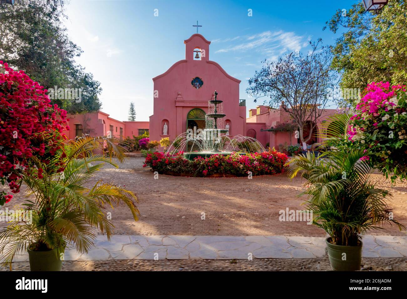 Ancient church with a fountain adorned with flowers on a sunny day at ...