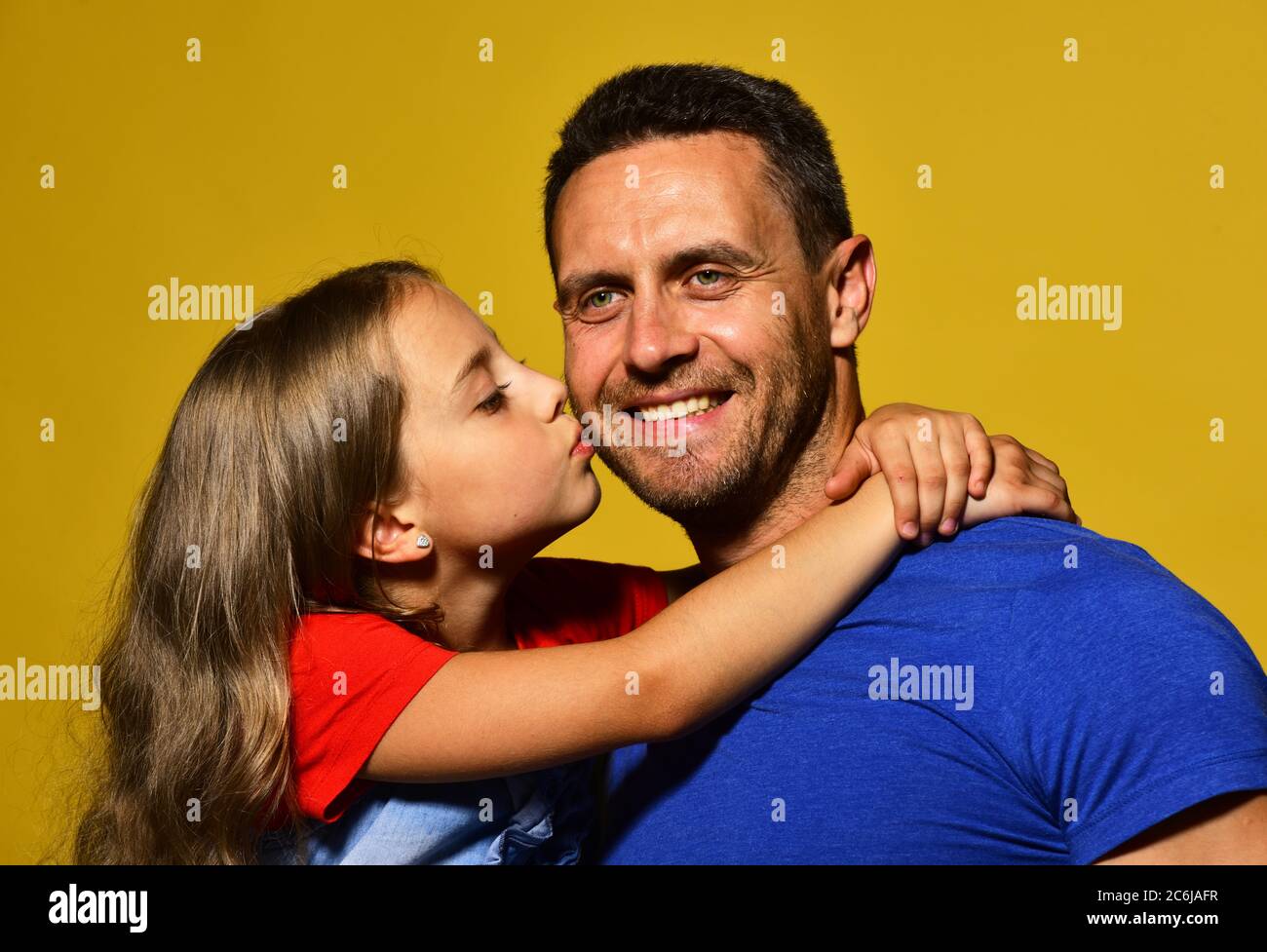 Daughter kisses her daddy in cheek. Child and father with smiling face ...