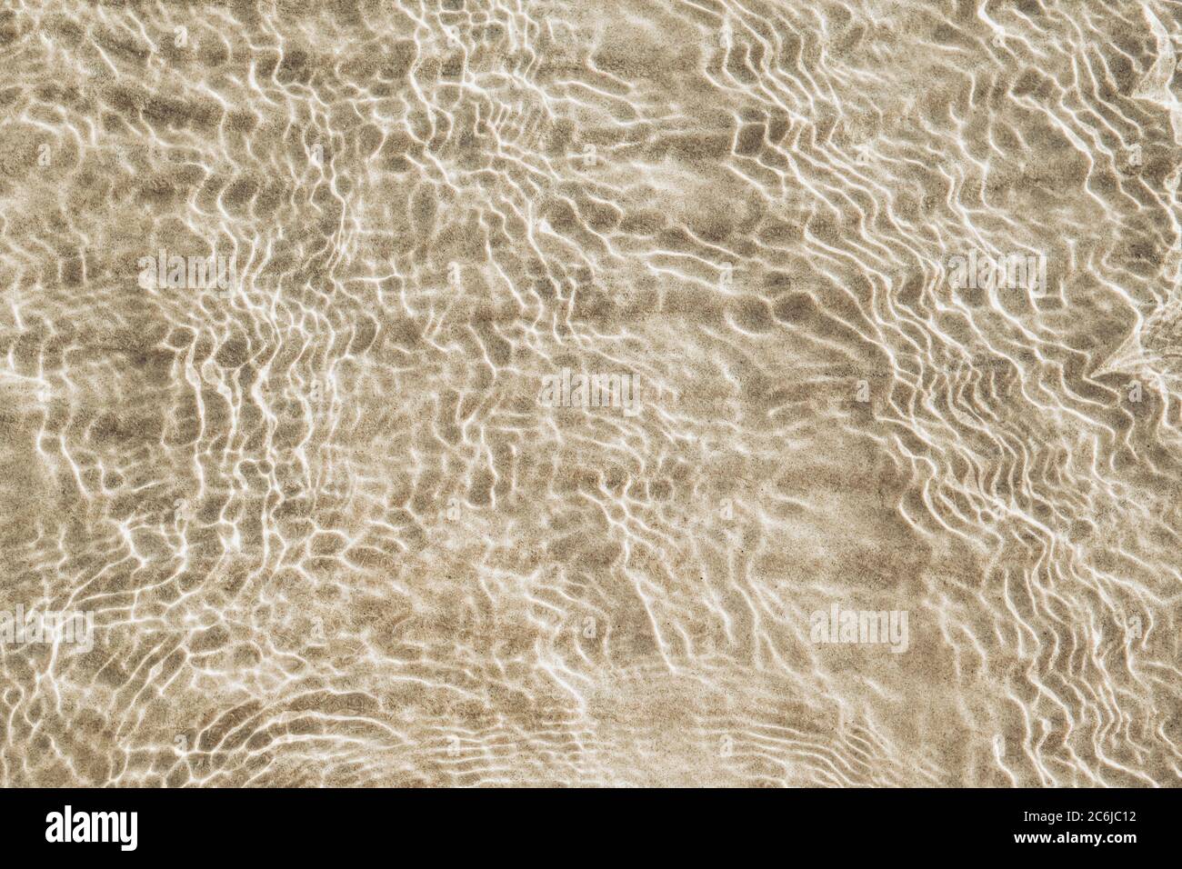 sand ripples under clear waves. Natural pattern. Still waters of the ...