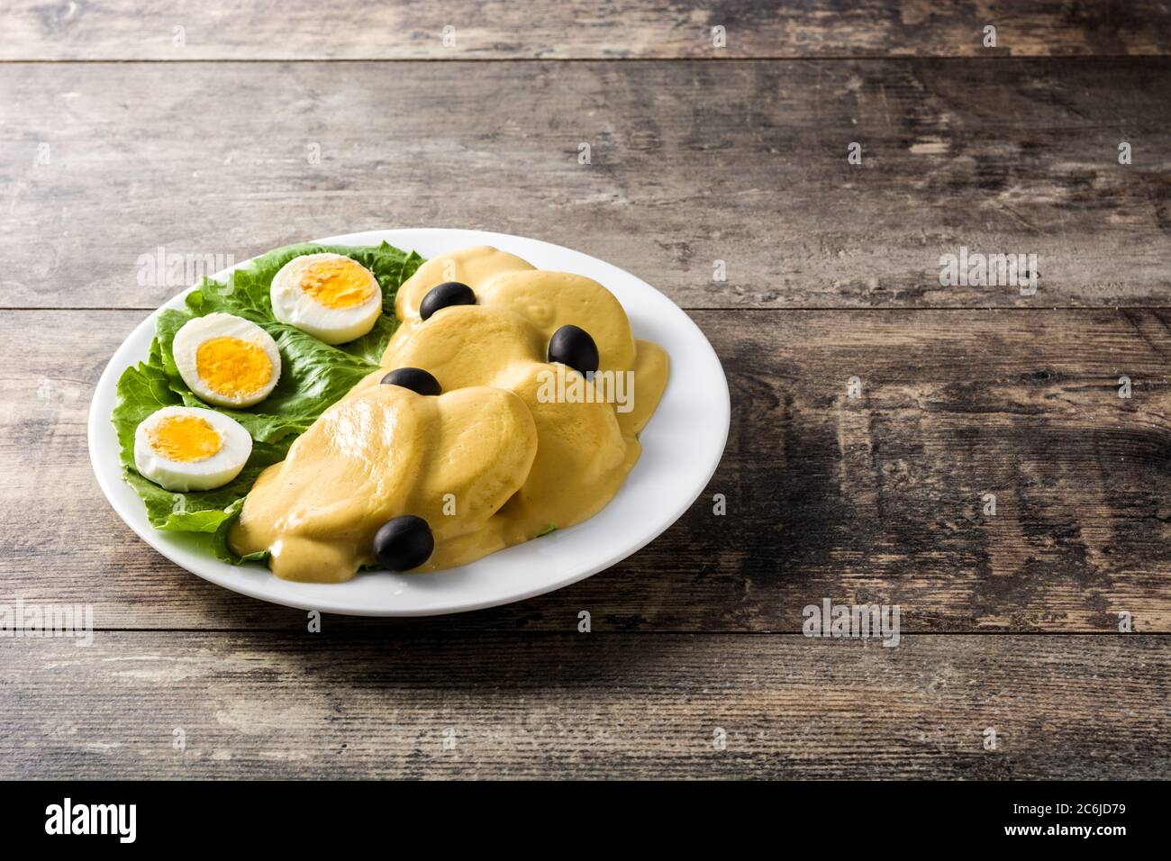 Traditional Peruvian papa a la huancaina on wooden table. Copy space ...