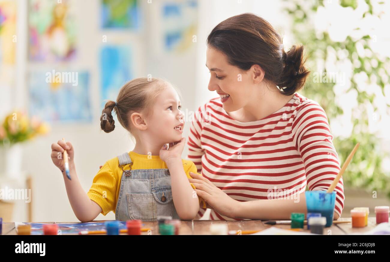 Happy family. Mother and daughter painting together. Adult woman ...
