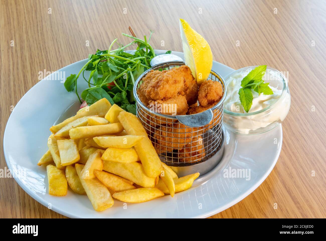 Traditional fried scampi fish and chips in a basket with mayonaise ...