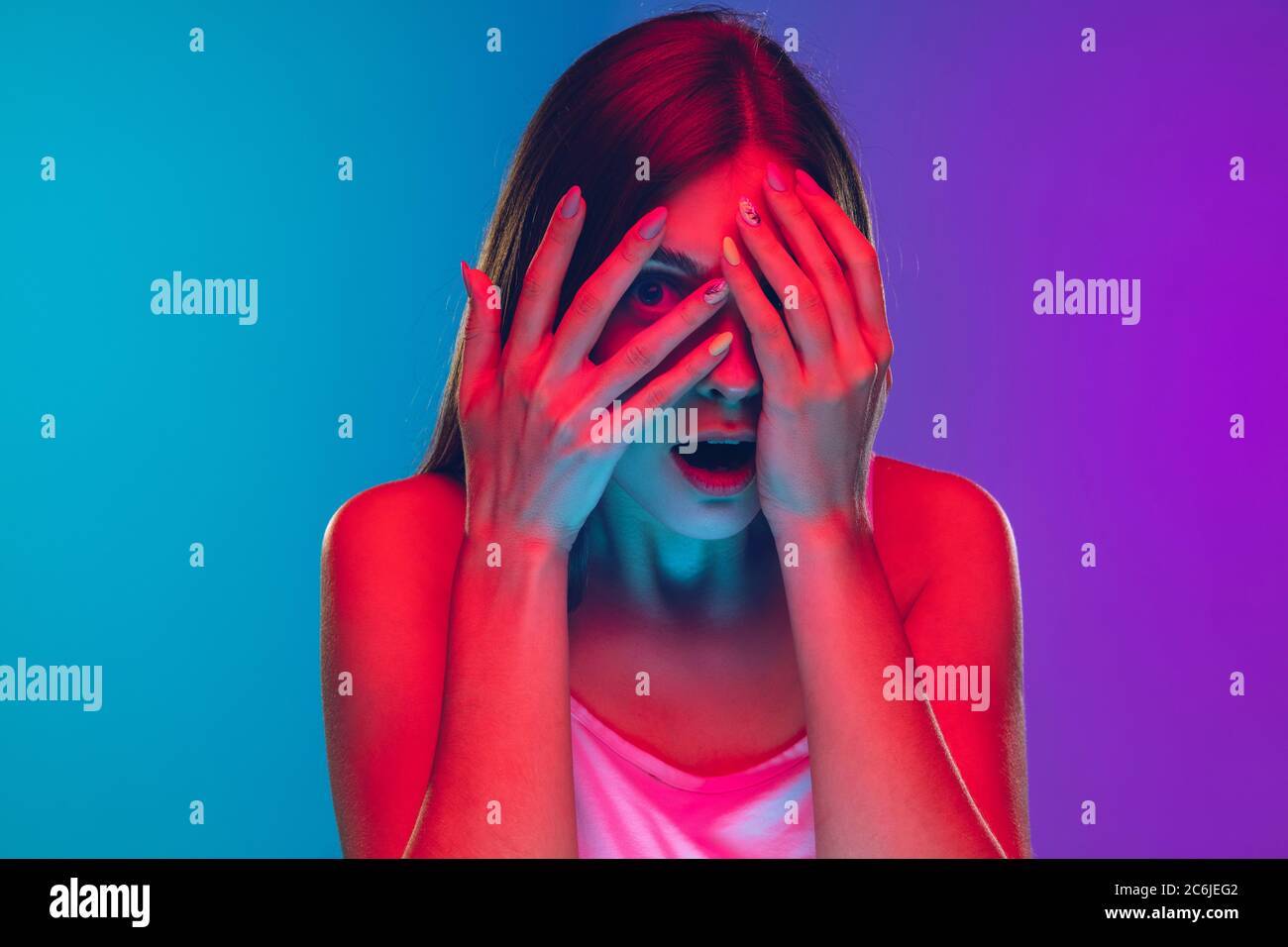 Shocked, scared, hiding face. Caucasian young woman's portrait on ...