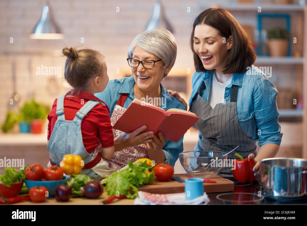 Healthy food at home. Happy family in the kitchen. Grandma, mother and ...
