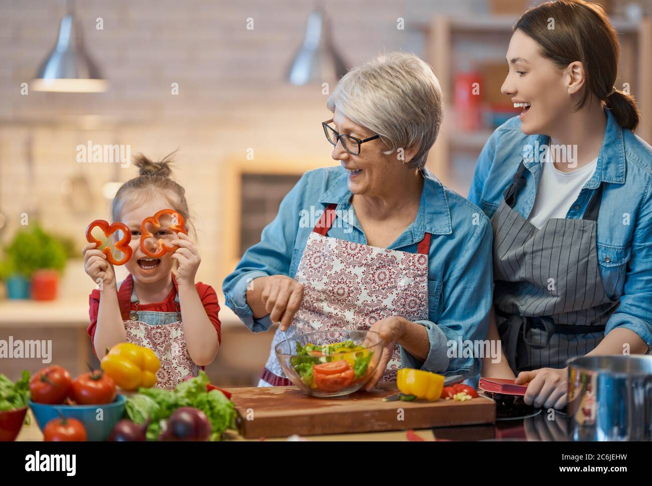 Healthy food at home. Happy family in the kitchen. Grandma, mother and ...