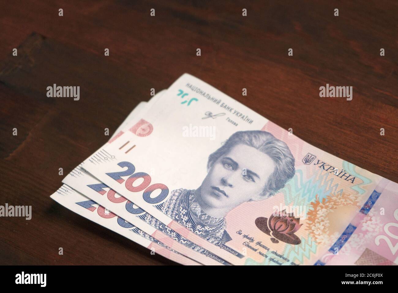 New Ukrainian paper money. Two hundred hryvnia notes on brown wooden ...