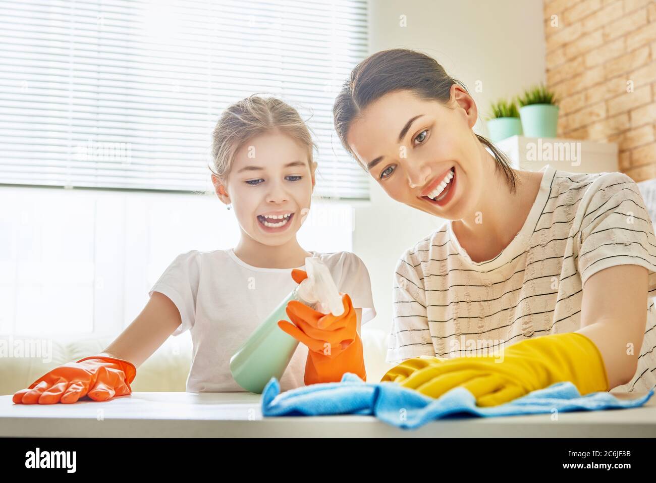 Happy family cleans the room. Mother and daughter do the cleaning in ...